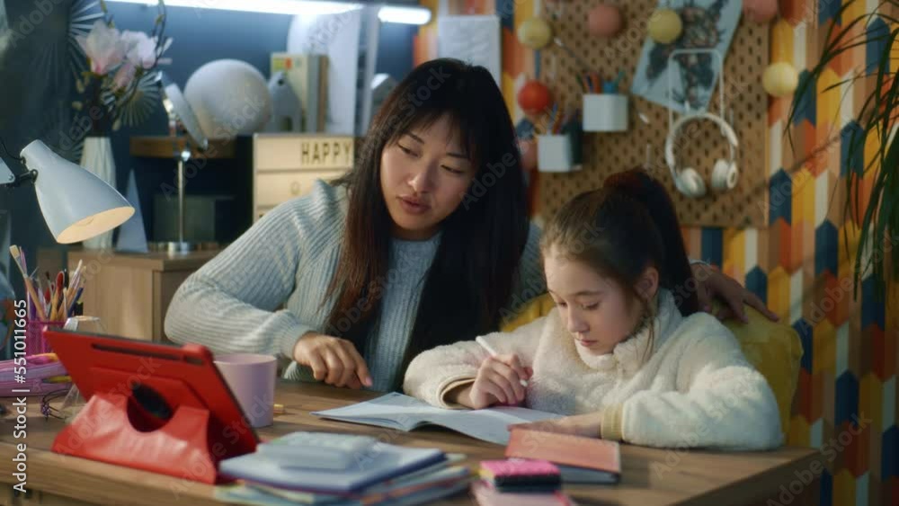Asian family making homework, discuss new material, sitting at the table and studying together ...