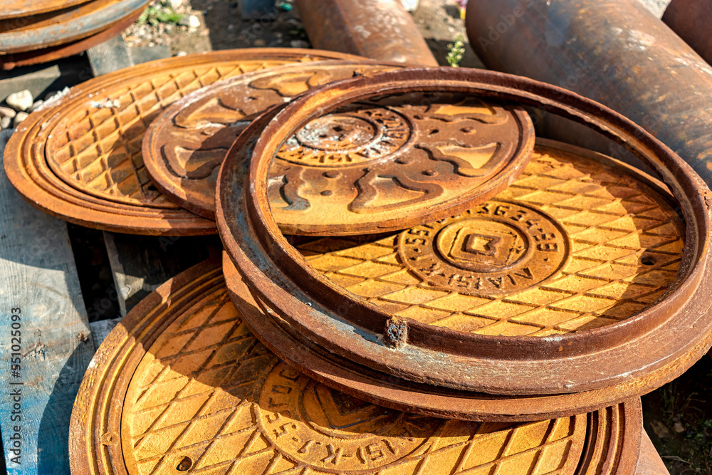 New cast iron manholes prepared for installation at the construction ...