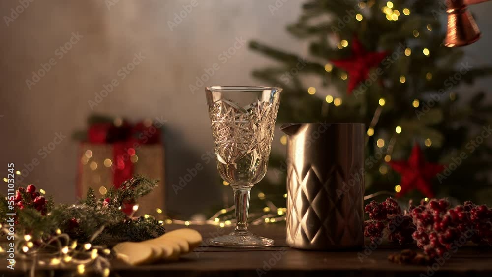 The bartender makes Christmas cocktails. A glass and a shaker are ...