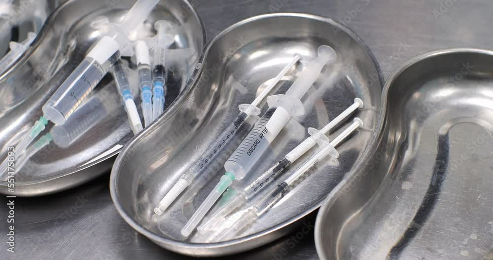 On the table are trays with syringes filled with medicines for ...