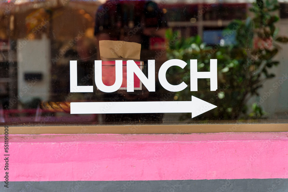 Painted Lunch and arrow symbol sign on a clear glass wall at Miami ...