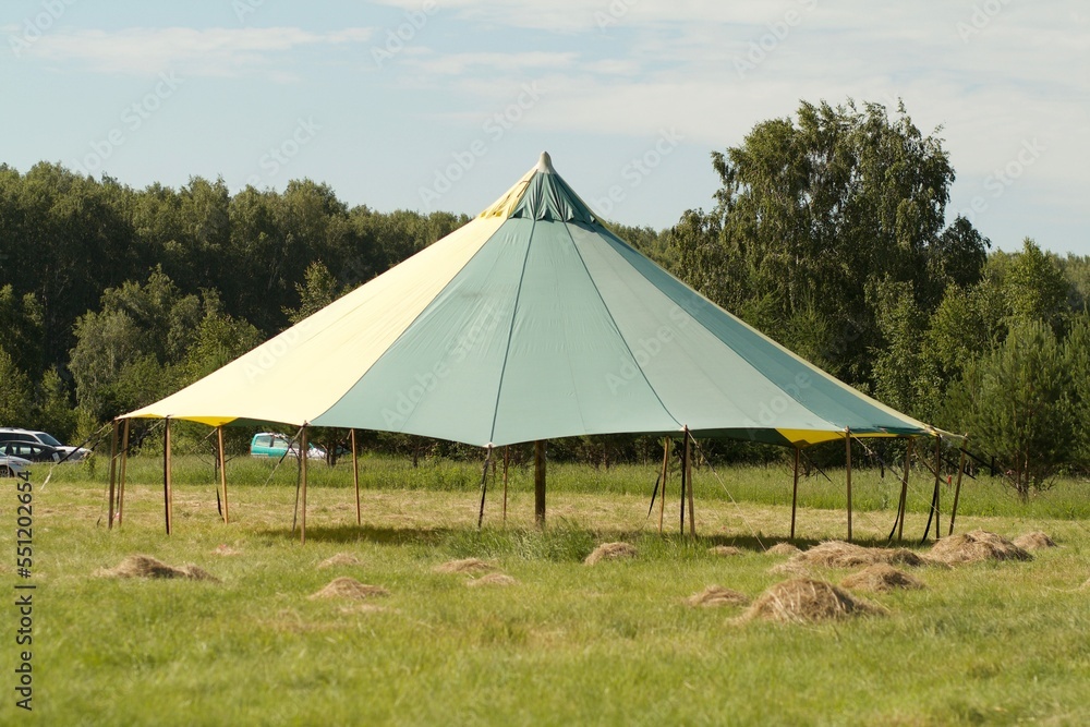 Foto de man and tent puts up a tent in a field tent in the forest the ...