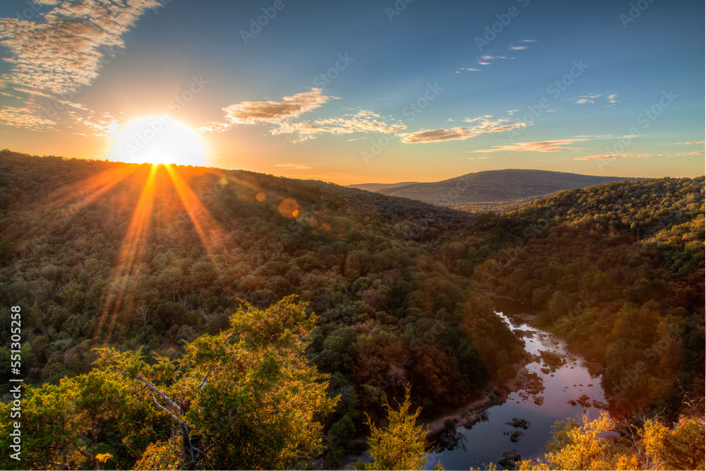A sunset scene with sun rays beaming from a huge sun on Lee Bluff Lee ...