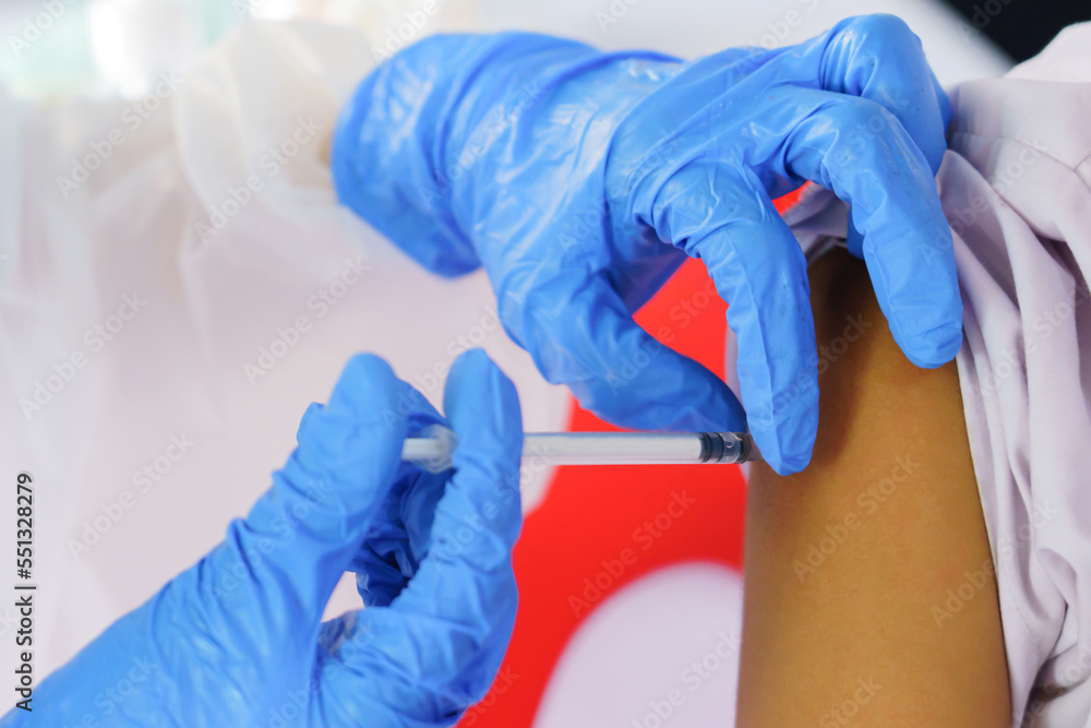 Nurse holding a syringe for the injection giving patient vaccine in ...