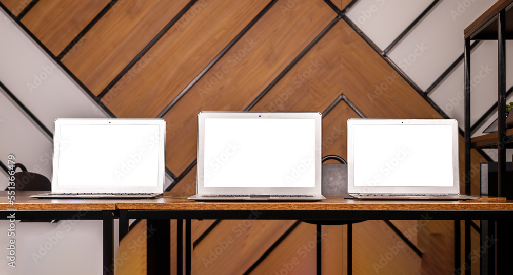 Multiple laptop screen mockups on wood desk in modern office. Multi ...