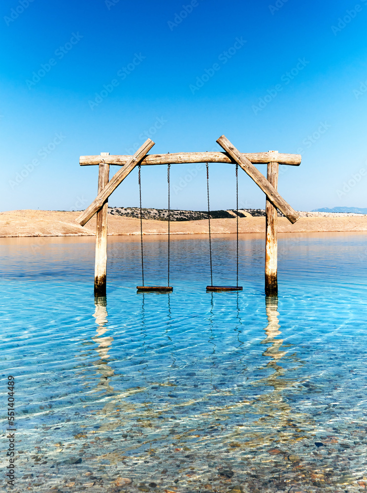 Empty swing in the water. Pebble beach on Adriatic coast of Croatia ...