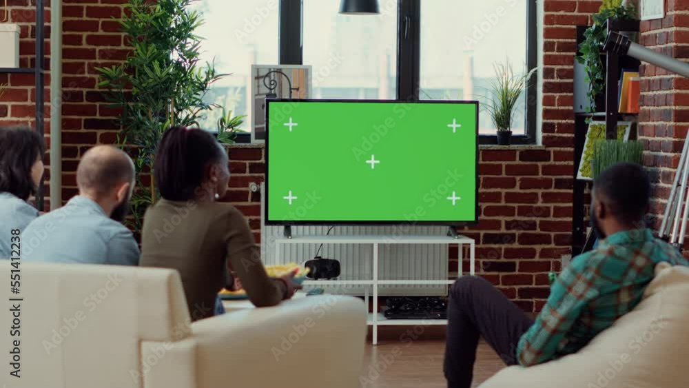 Multiethnic group of people enjoying tv show on greenscreen, watching ...