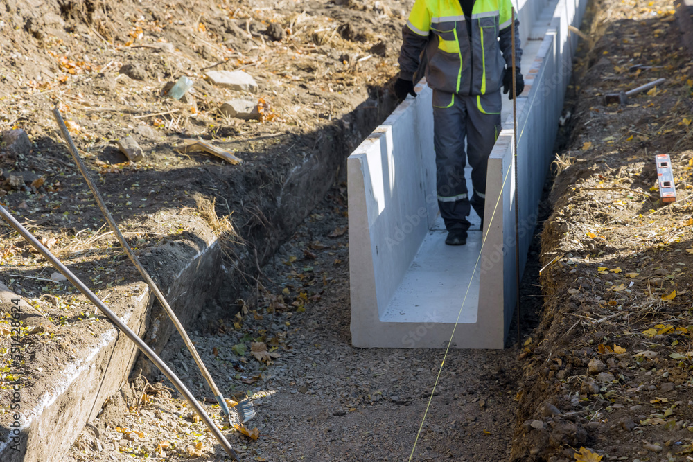 Installation of precast concrete u-shaped drains on reconstruction road ...