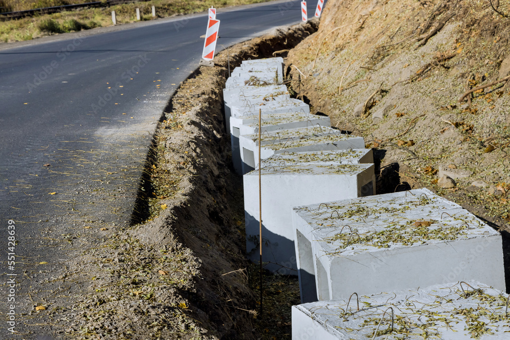 Installing precast u-shape concrete drains along reconstruction road ...