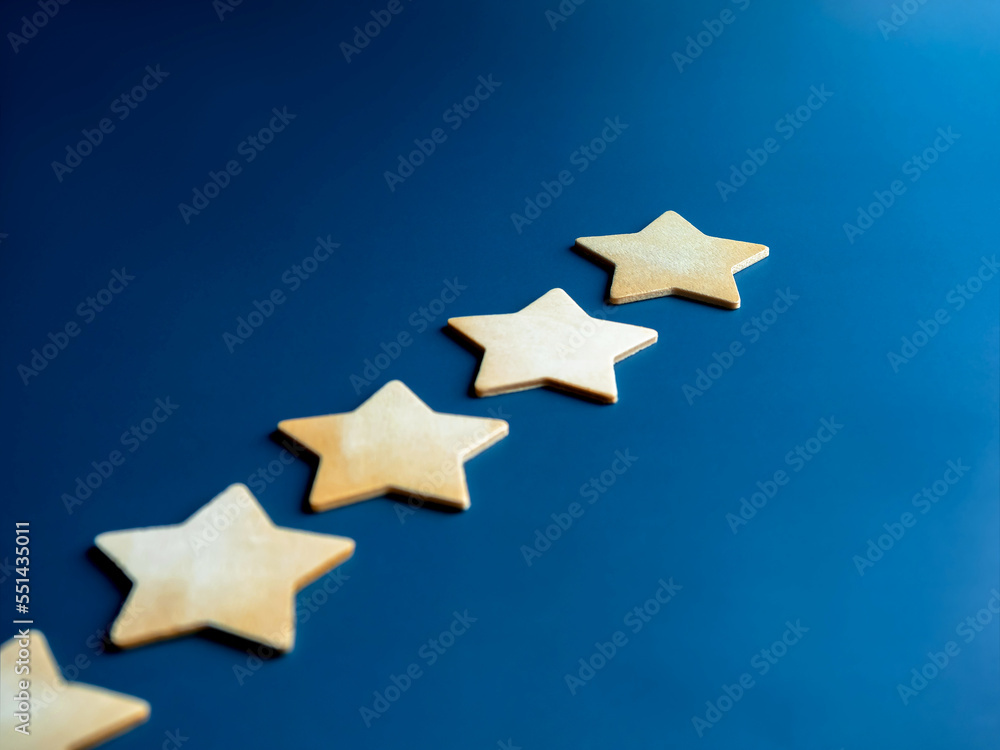 Five wooden stars as a chart step, excellence ranking award on blue ...