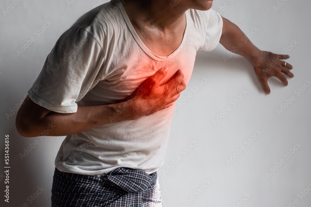Asian man suffering from central chest pain. Chest pain can be caused ...