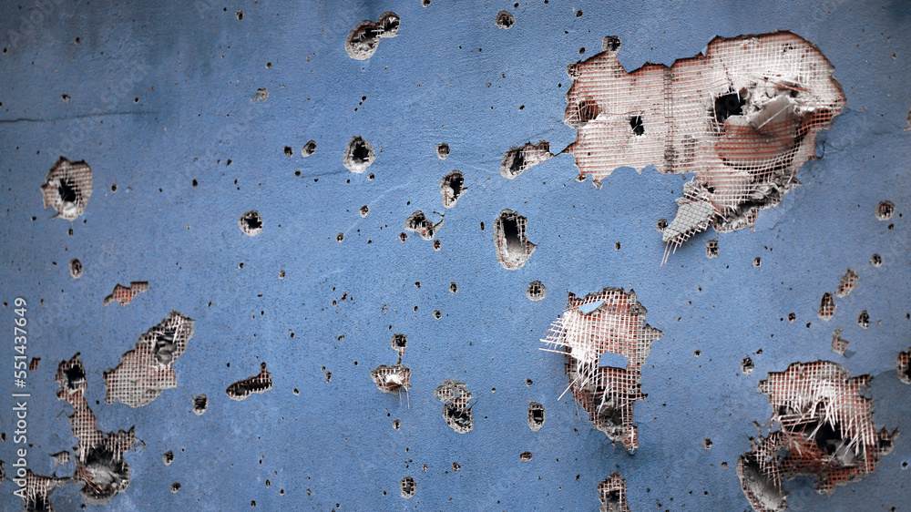 Holes from artillery shell fragments in the wall of an apartment ...