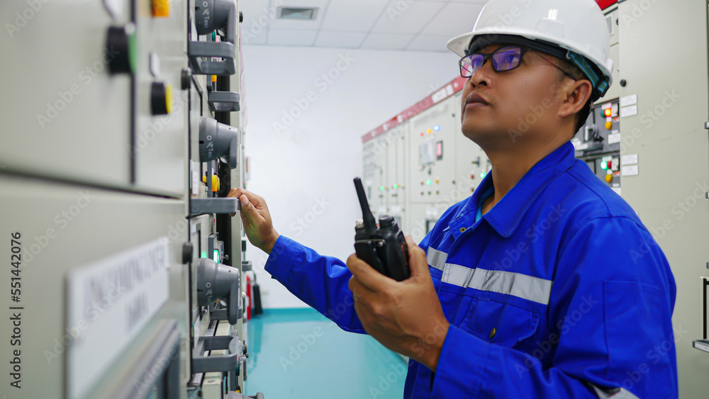 An electrical maintenance worker working in a station building inspects ...