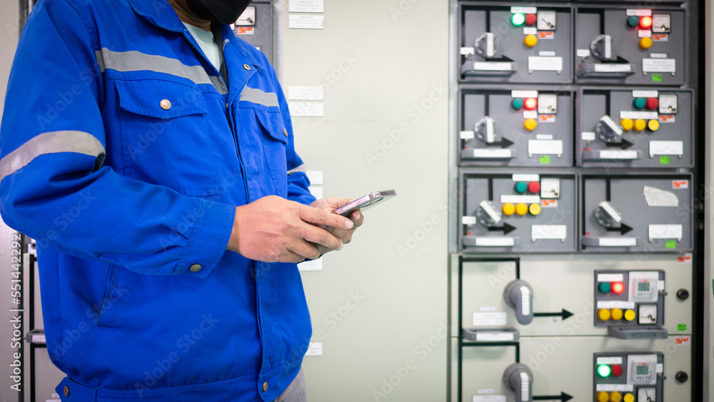 Electrical engineer working in substation building checking electrical ...