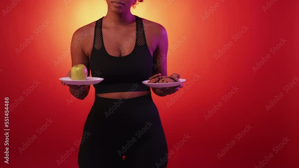 Hard choice. Doubtful woman. Diet problem. Sportive lady holding plates ...