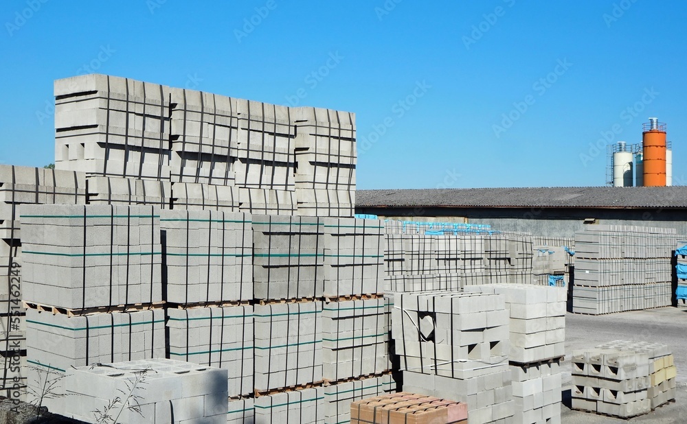 Concrete blocks stacked outside the precast concrete factory. Silos on ...