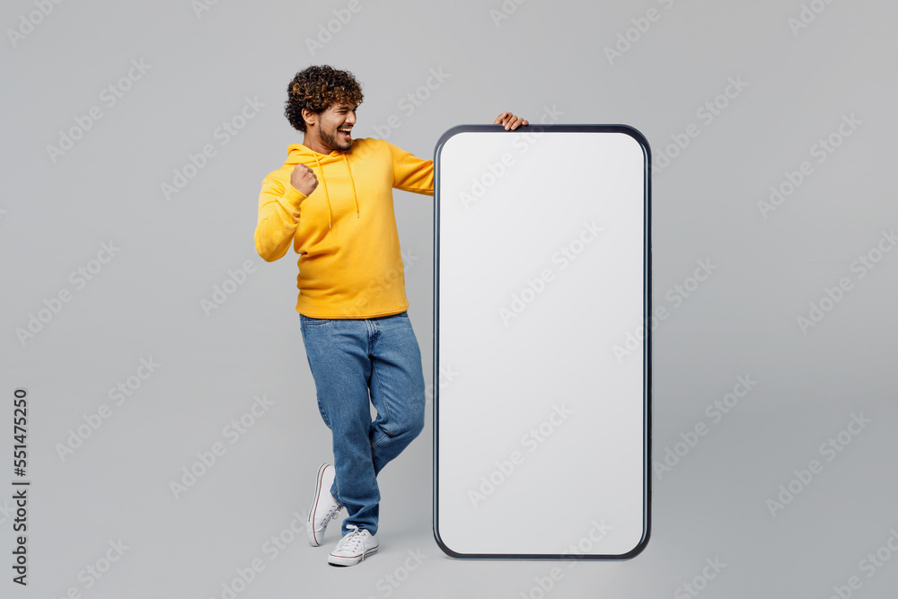 Full body happy young Indian man wears casual yellow hoody stand near ...