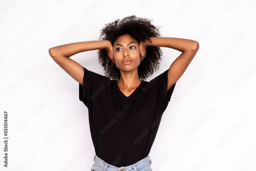 Portrait of ignorant young woman covering ears with hands over white ...