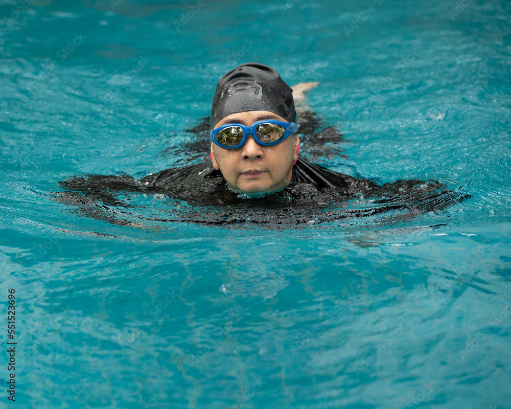 Happy active senior woman has fun swimming in swimming pool. Portrait ...