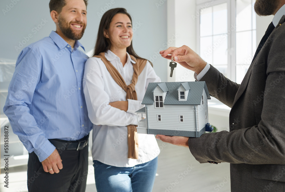 Realtor gives the key to a happy, smiling family. Real estate agent ...