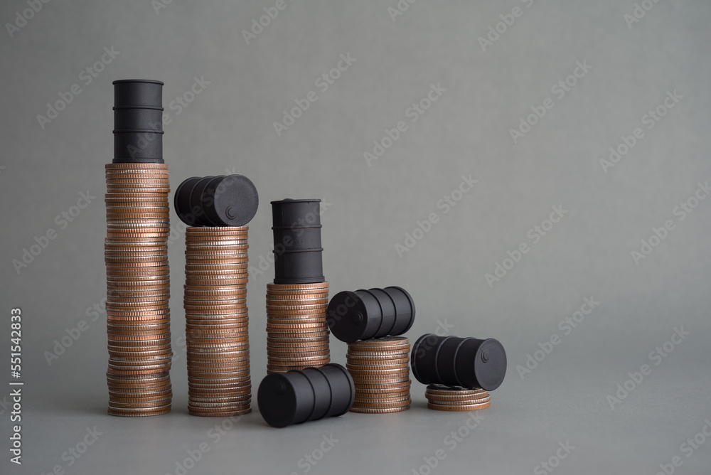 Crude oil tank on stack coins as price chart graph falling down on grey ...