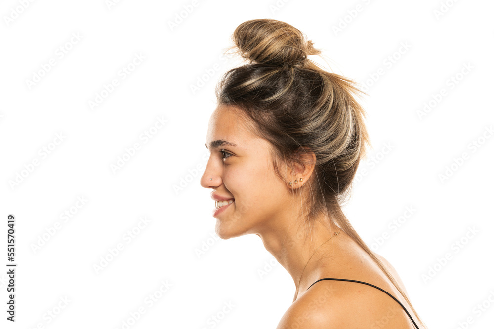 smiling woman with messy loose bun and no makeup on a white studio ...