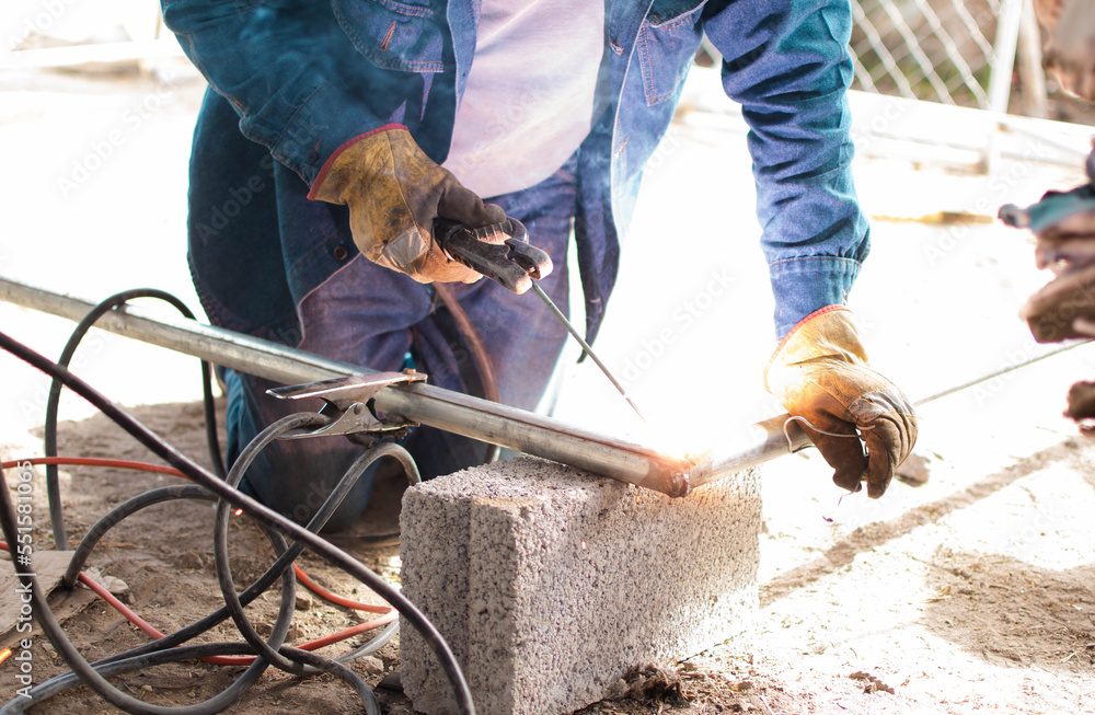Hombre moreno adulto soldando un tubo de metal Stock Photo | Adobe Stock