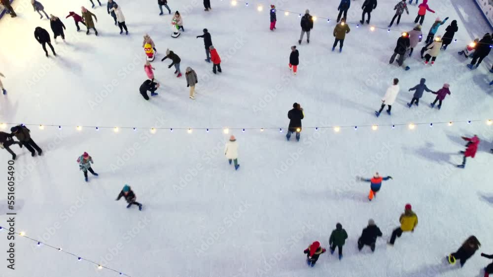 Flight Over many people skating on an open-air ice skating rink in ...