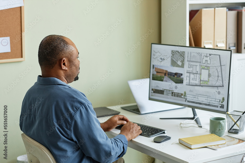 Side view portrait of black man as architect using computer and ...