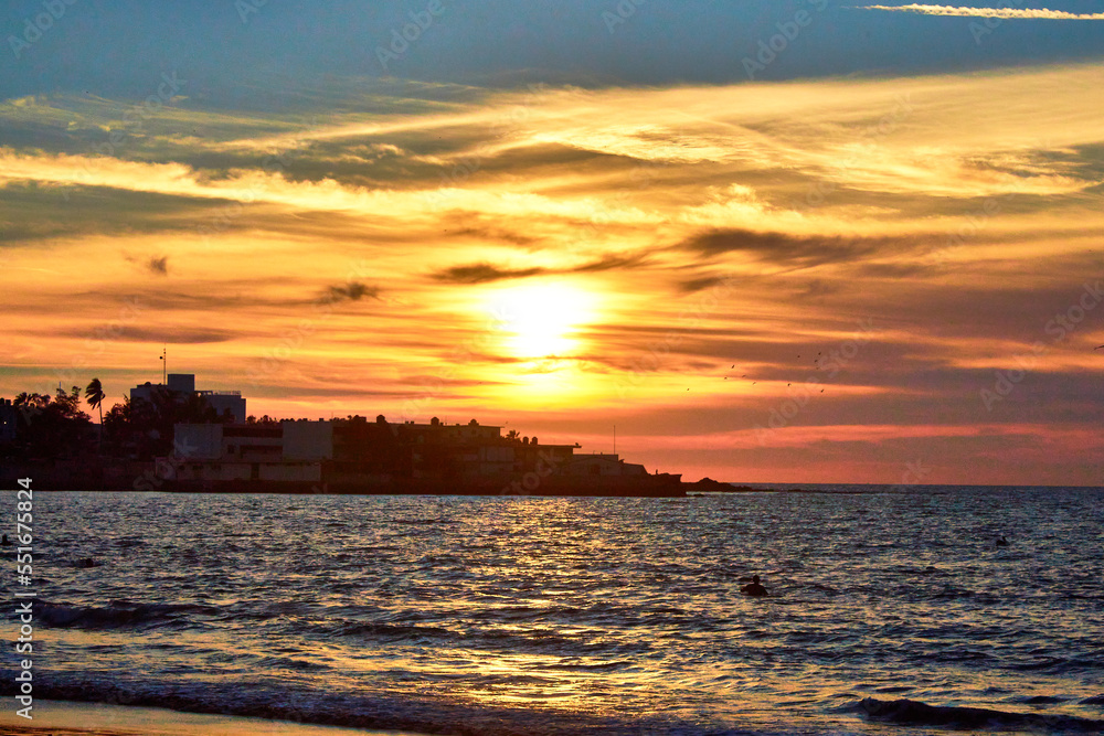 golden sunset on the beach with silhouette of coast in the background ...