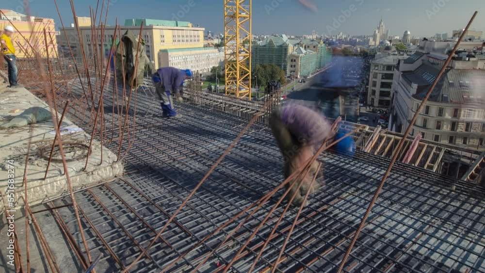 Construction workers working on steel rods used to reinforce concrete ...