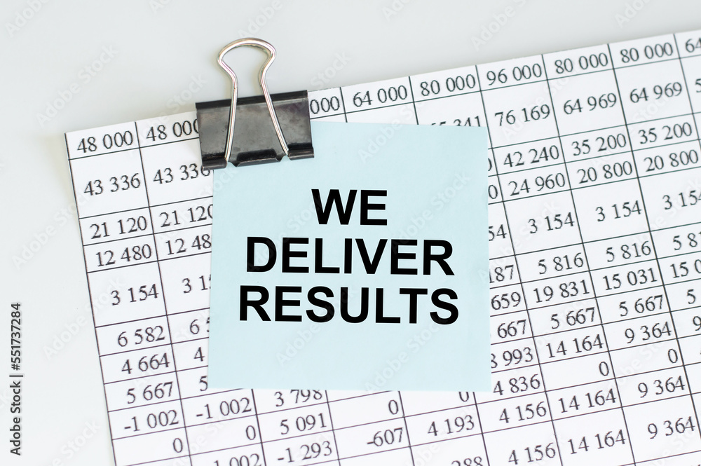 WE DELIVER RESULTS text on the white paper on light background with ...