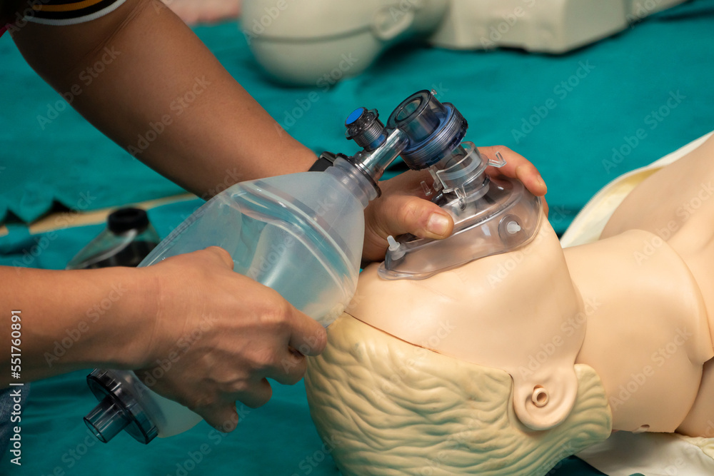 Demonstrating CPR (Cardiopulmonary resuscitation) training medical procedure on CPR doll in the ...