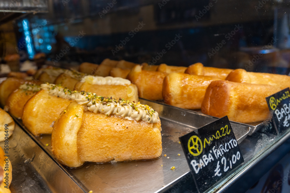 Typical Neapolitan sponge cake called Babà, in a shop window of a ...