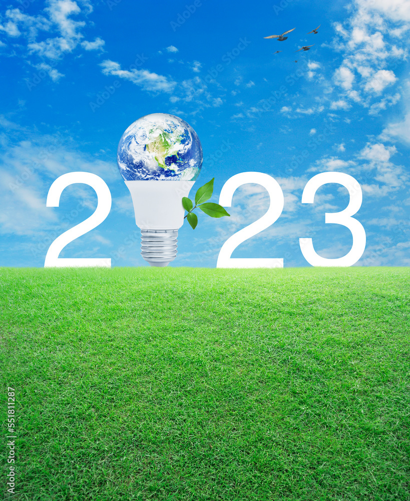 Earth globe inside led light bulb with fresh tree leaves and 2023 ...