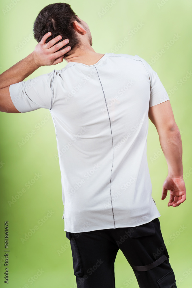guy in a white t-shirt on a green background. the back of a man in a ...