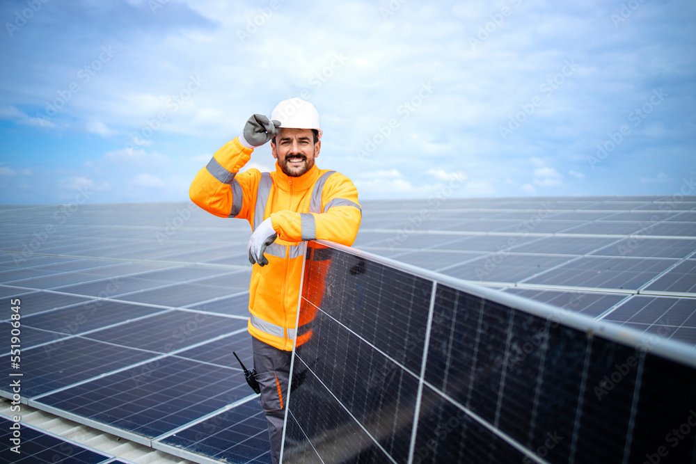 Portrait of smiling worker proudly standing on the rooftop after ...