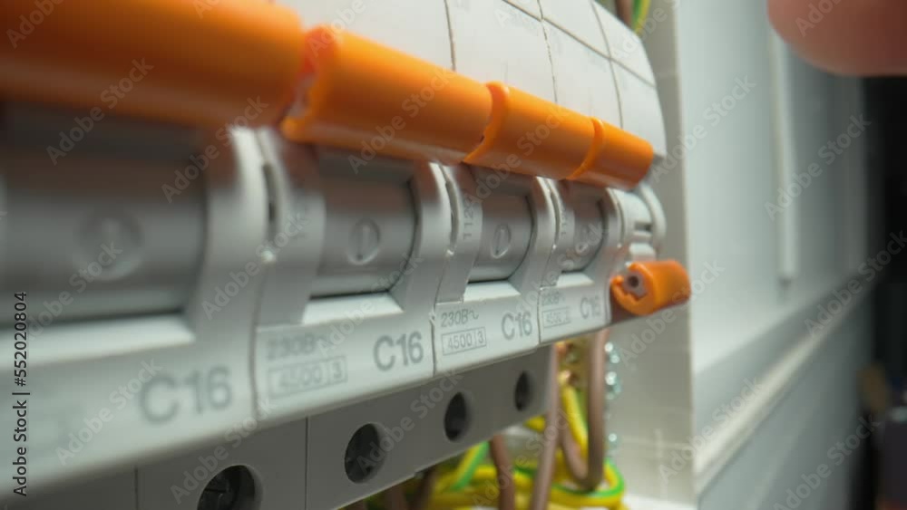 Finger turning on high voltage electrical switches in switchboard ...