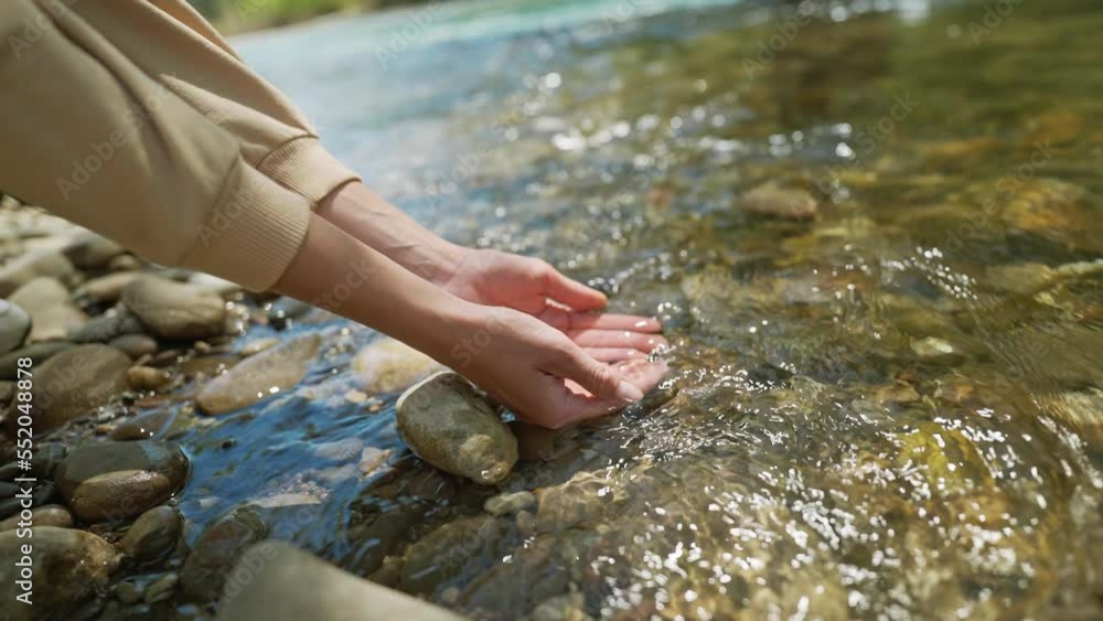close up slow motion female hands taking fresh cold clean water in ...