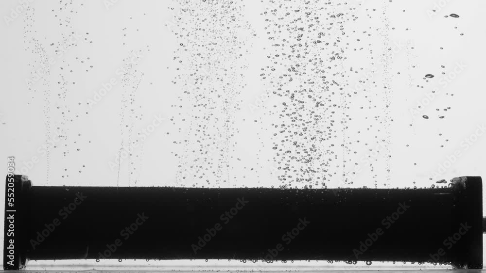 Dark air bubbles escaping from black paralon tube. Compressor, aerator ...