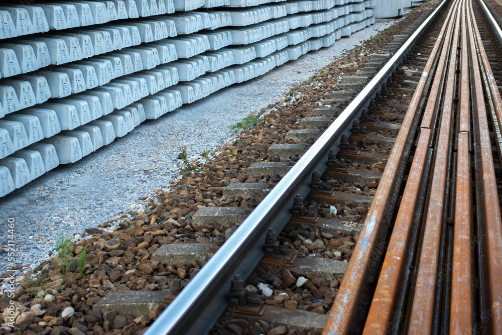 Expansion of railway lines. Train rails ready for laying and concrete ...