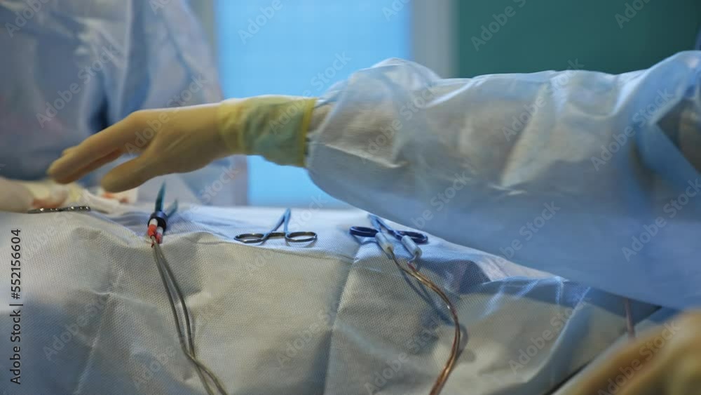 Surgical tools and instruments are placed on top of the patient. Nurse ...