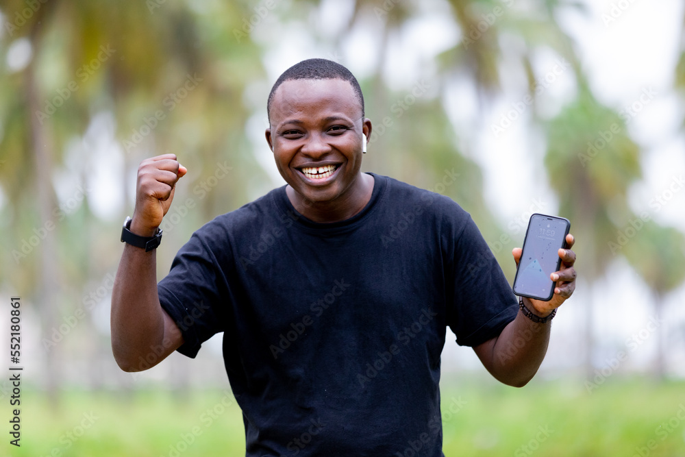 Cheerful smiling black african young man in village in Africa pointing ...