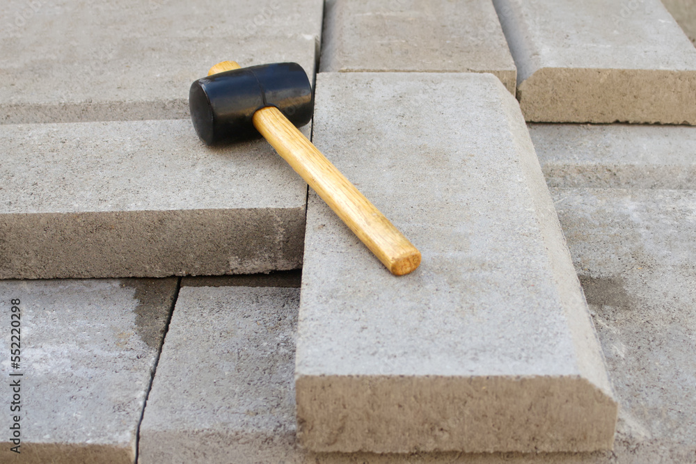 Defocus paving hammer. Stack of paving stones. Garden brick pathway ...