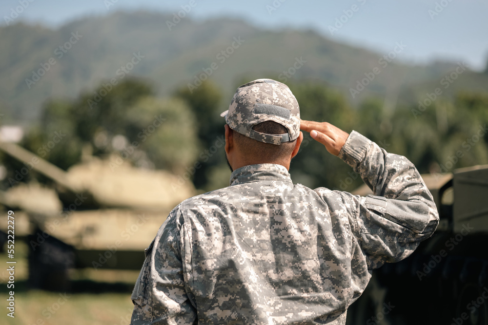 Asian man special forces soldier saluting standing against on the field ...