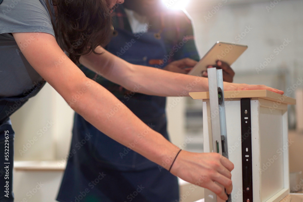 Professional carpenters using a ruler and spirit level to measures a ...