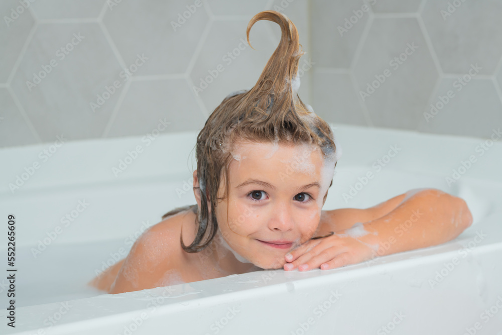 Kids shampoo. Kid having fun in the bath with bubbles. Happy child ...