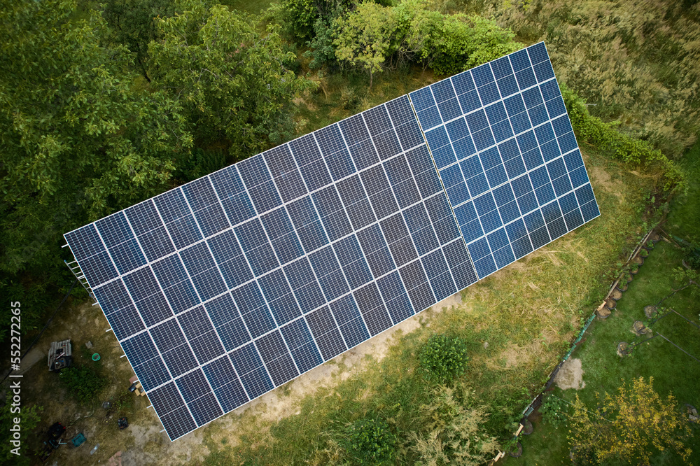 Aerial view of solar panels in green field at daytime. Different types ...