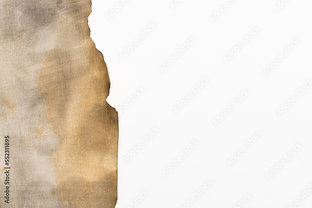 Burned and stained piece of paper with copy space on white background ...
