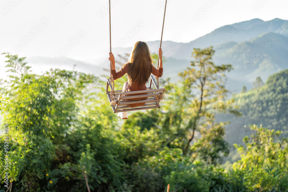 Traveler girl sitting on swing rope hang from tree branch swing on ...